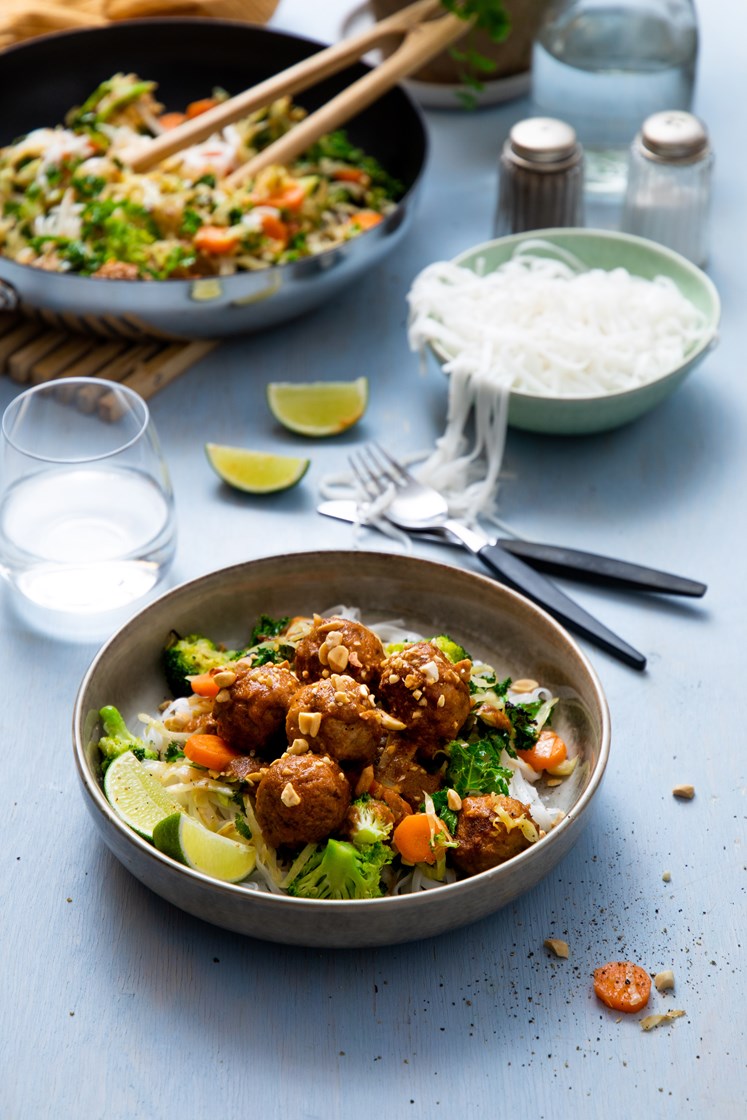 Kjøttboller av svin i sataysaus servert med risnudler og wokede ...