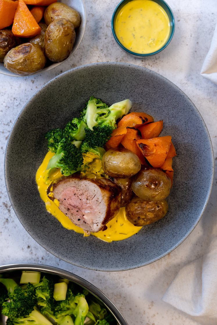 Filetstykke av svin med kokte poteter og brokkoli, bakte gulrøtter, og ...